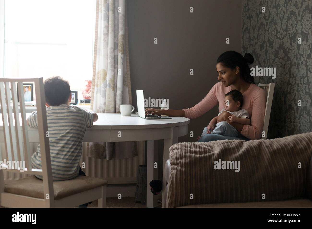 Mother multi-tasking work and children Stock Photo - Alamy