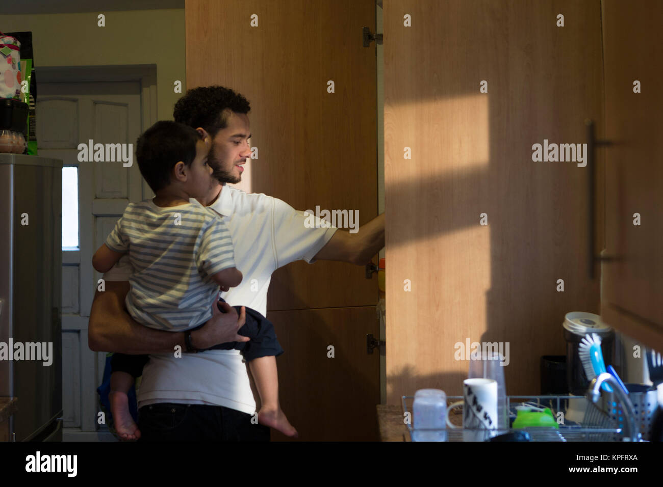 Helping daddy make food Stock Photo - Alamy