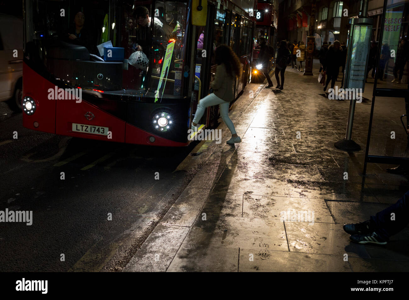 Commuters board a London bus in winter darkness on the Strand, on 12th ...
