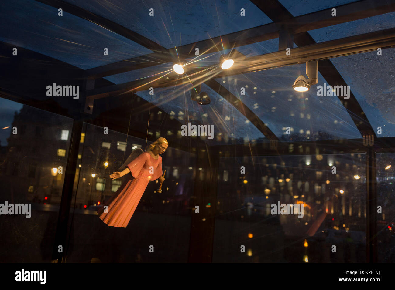 Three spotlights illuminate a angel floating over a nativity scene by ...