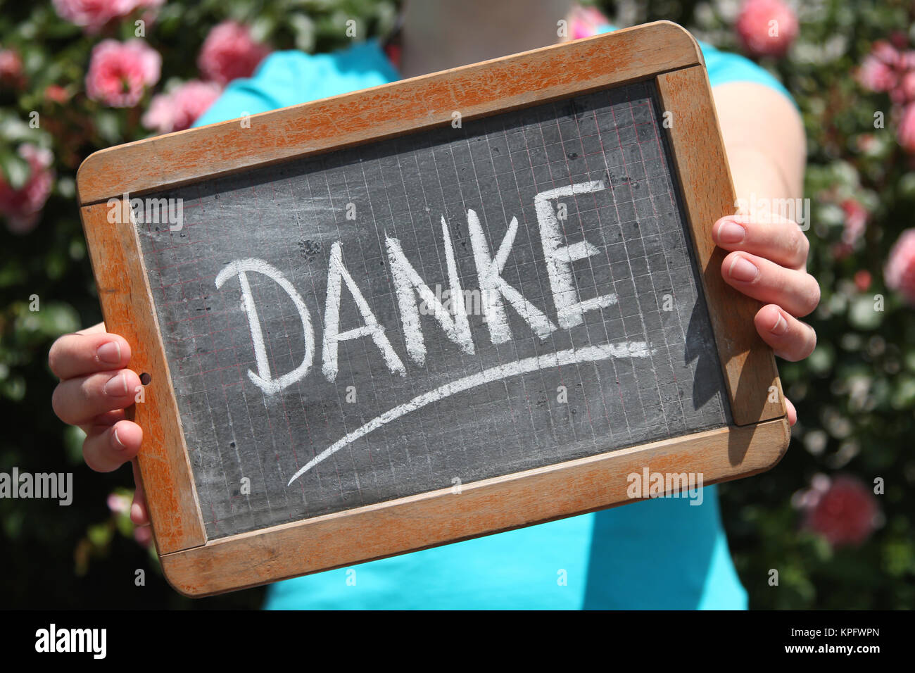 DANKE (thanks in German) written with chalk on slate shown by young ...
