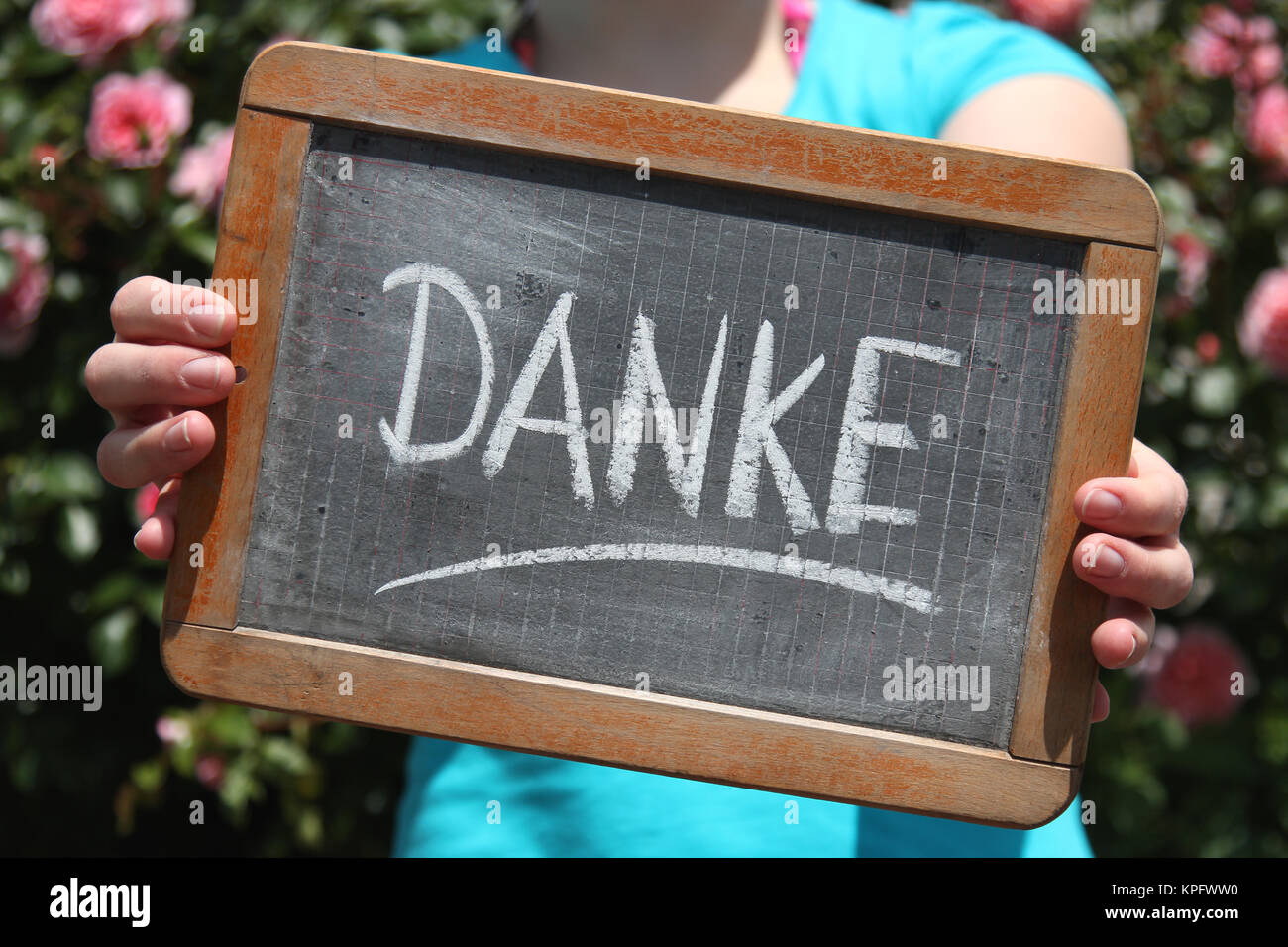 DANKE (thanks in German) written with chalk on slate shown by young ...