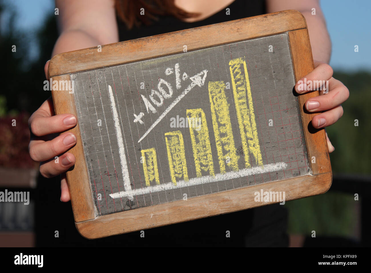 upturn graph sketched with chalk on slate shown by young female Stock ...