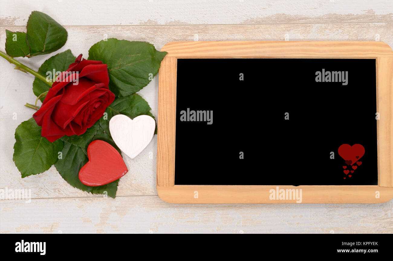 red rose and black slate on a wood background Stock Photo - Alamy