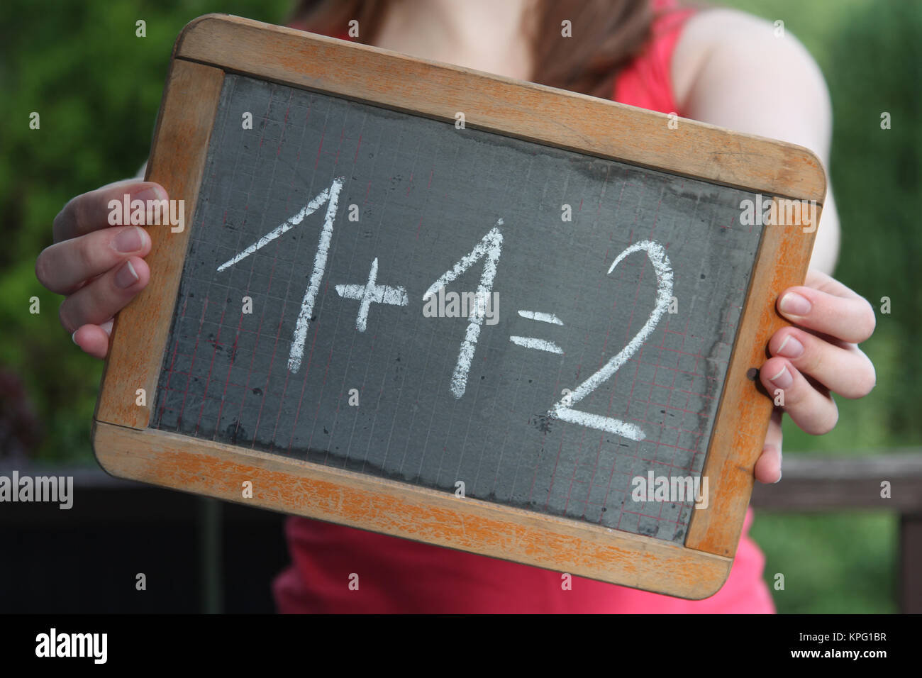 1+1=2 written with chalk on slate shown by young female Stock Photo - Alamy