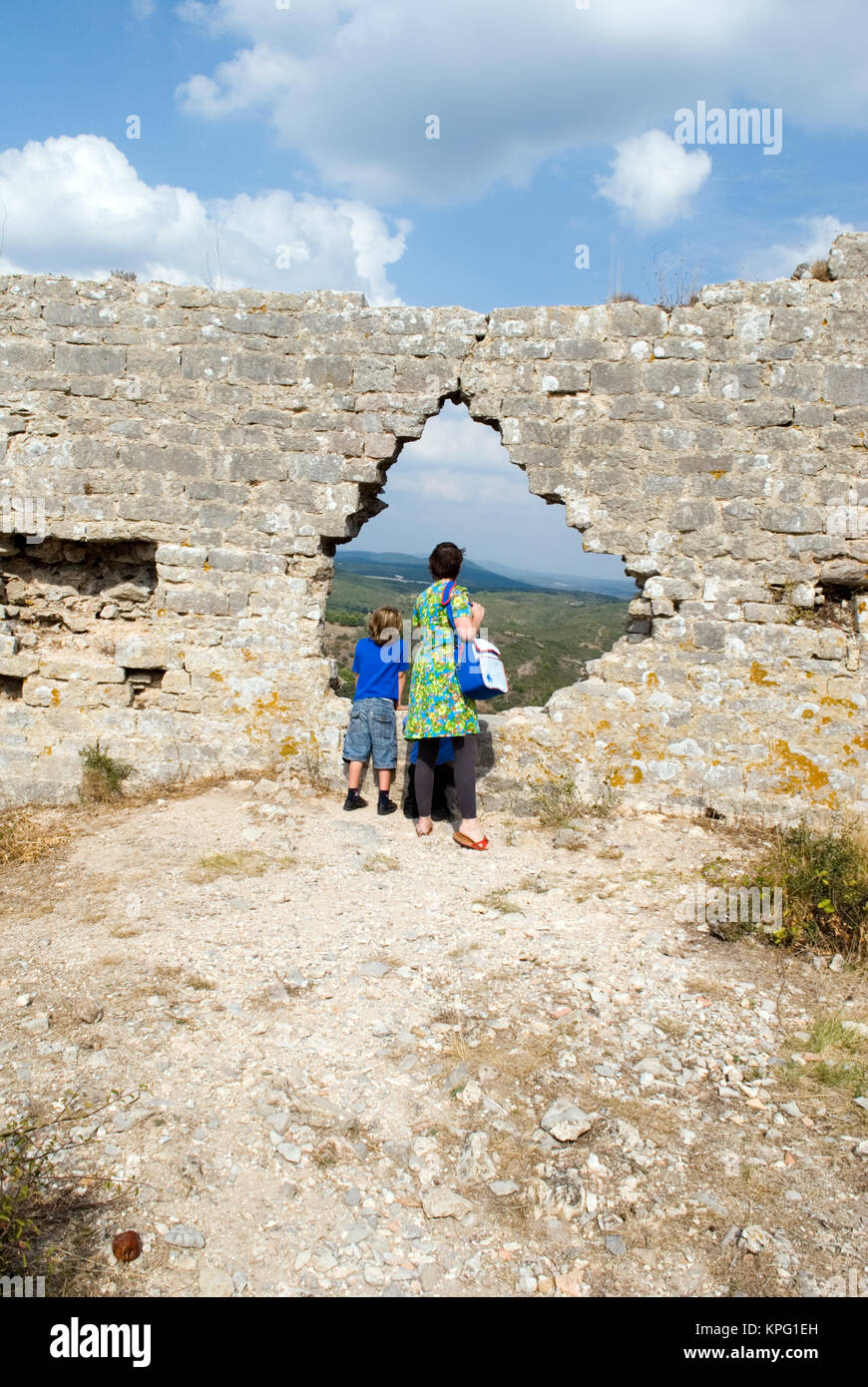 mother and son look through broken castle wall overlooking the Bueges ...