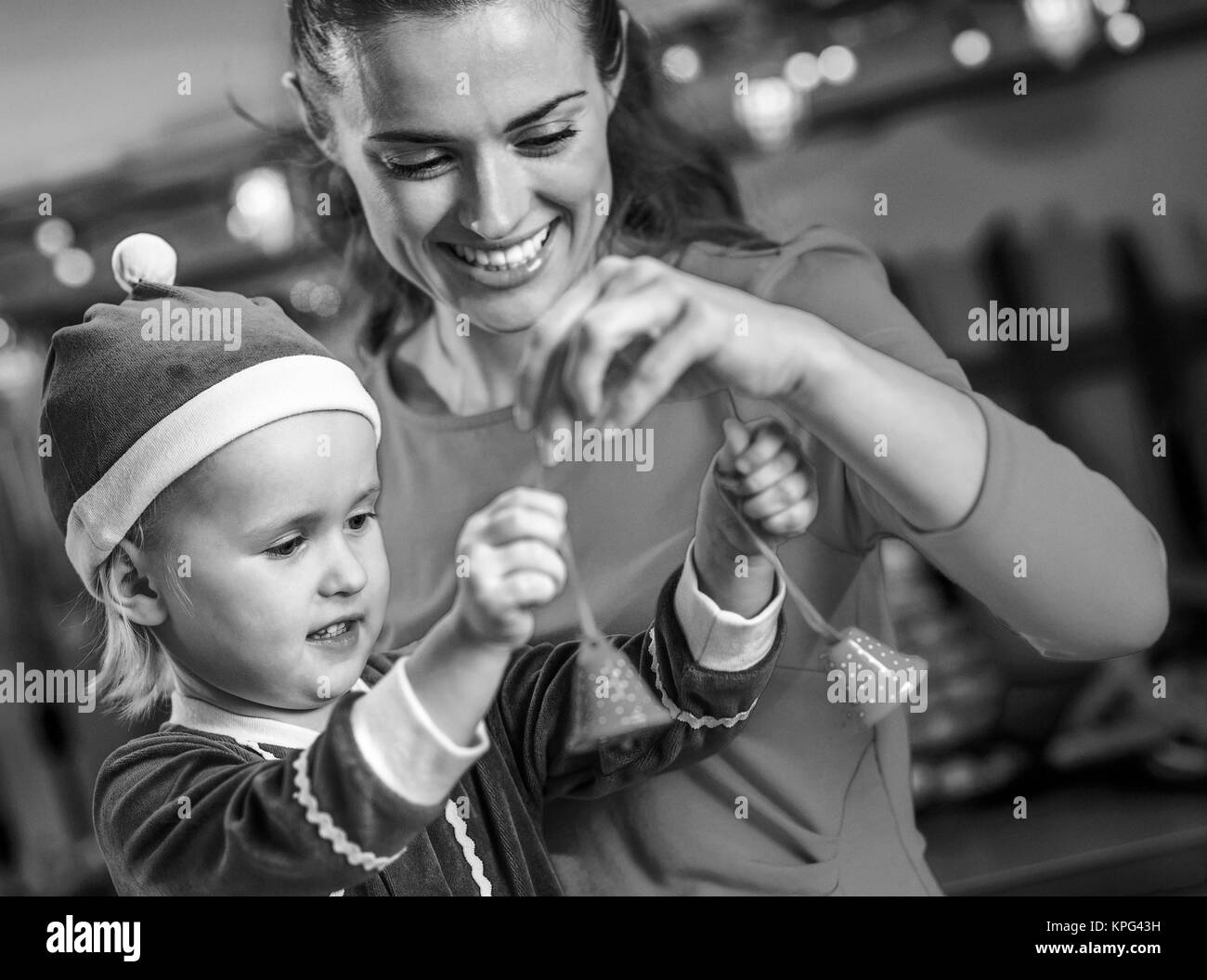 Happy mother and baby playing with christmas bells Stock Photo - Alamy