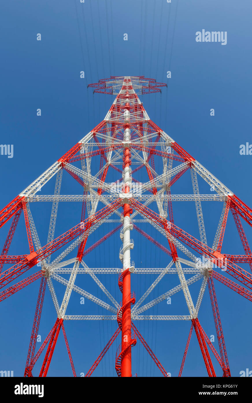 Red and white electricity pylon against blue sky, low angle view Stock ...