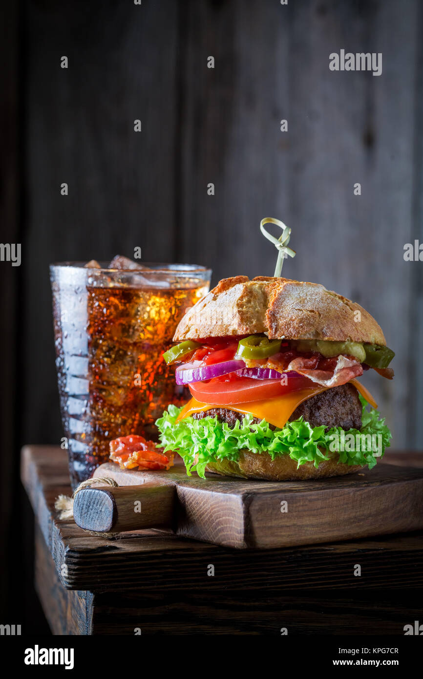 Spicy and fresh hamburger and cold drink with ice Stock Photo - Alamy