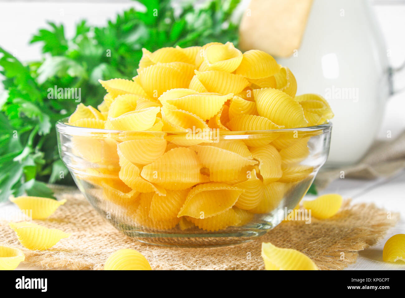 Culinary background with conchiglie pasta on wooden table. Pasta in the ...