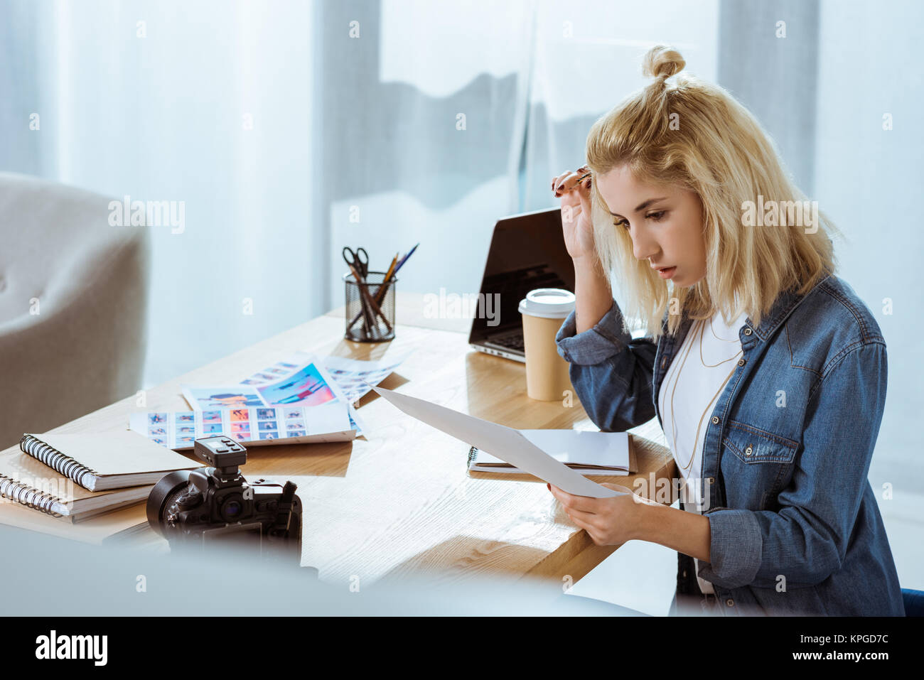 portrait of thoughtful photographer looking at photoshoot examples at ...