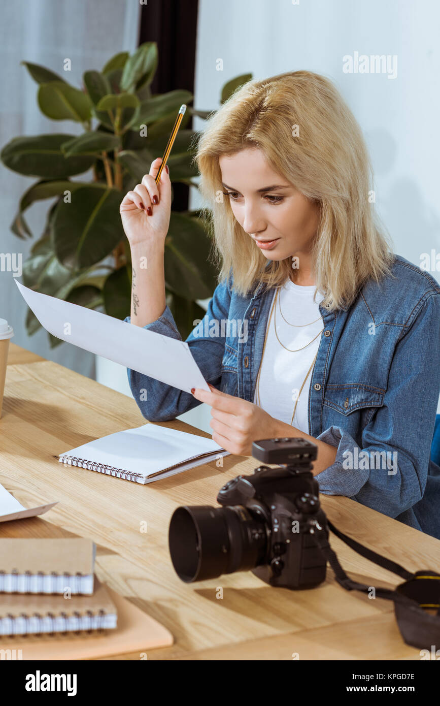 portrait of young photographer looking at photoshoot samples at ...
