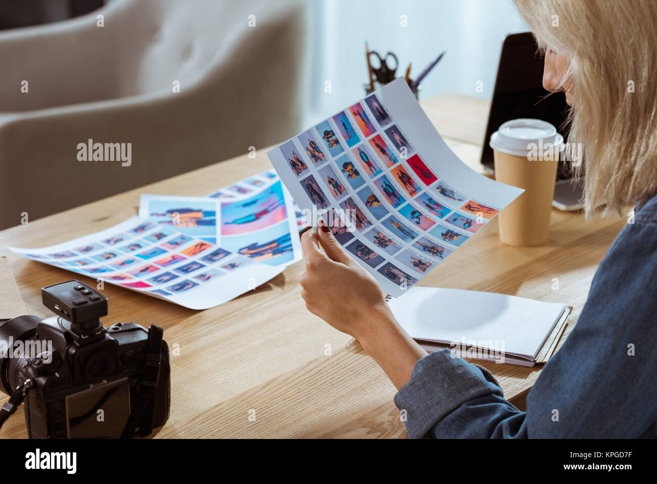 partial view of photographer looking at photoshoot samples at workplace ...