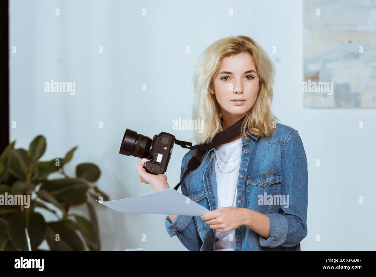 portrait of young photographer with photo camera and photoshoot example ...