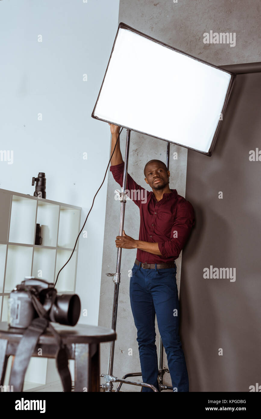 african american photographer getting ready for photoshoot in studio ...