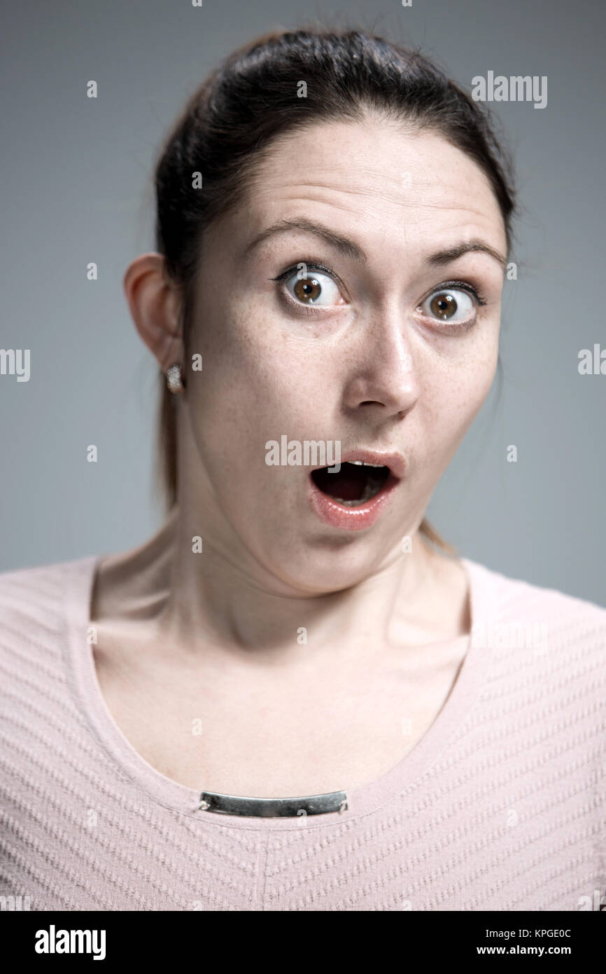 Portrait of young woman with shocked facial expression Stock Photo - Alamy
