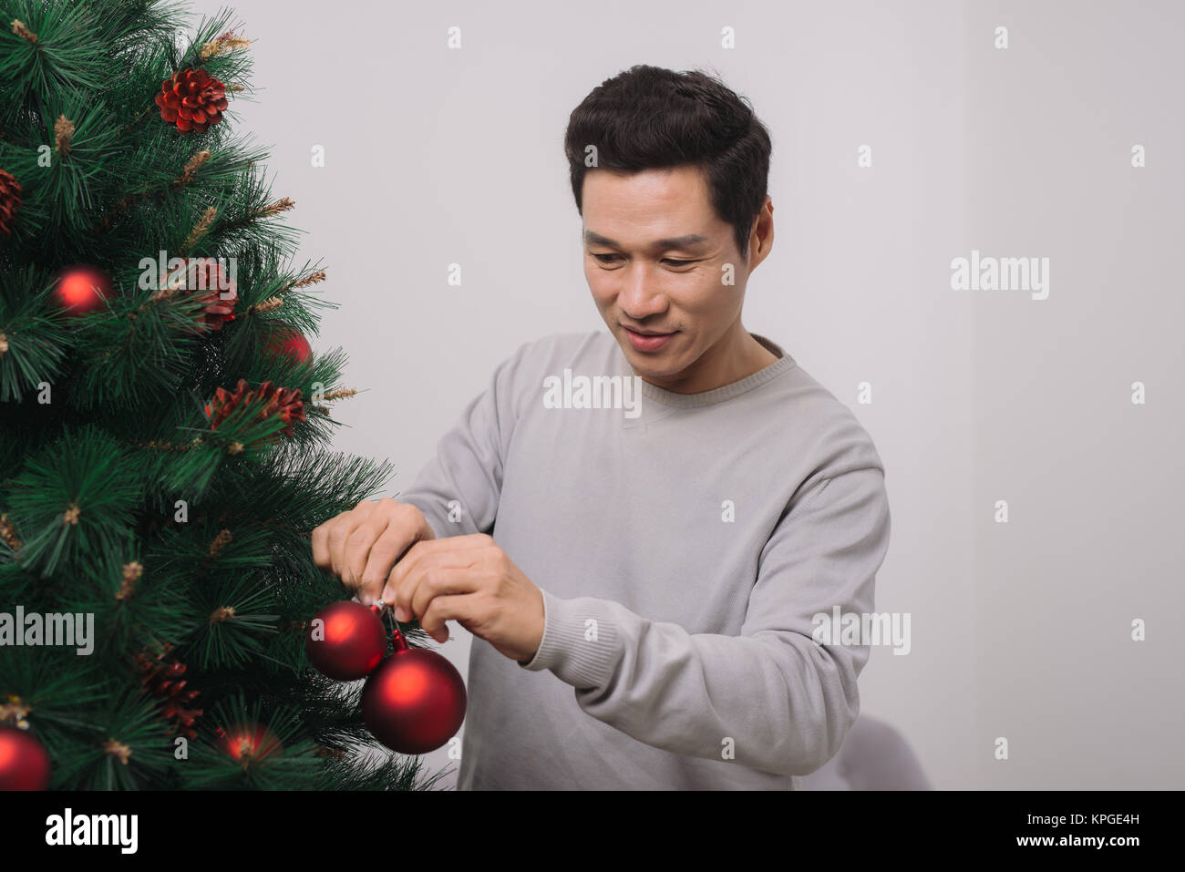 Christmas. Asian man standing new christmas tree at home celebrating ...