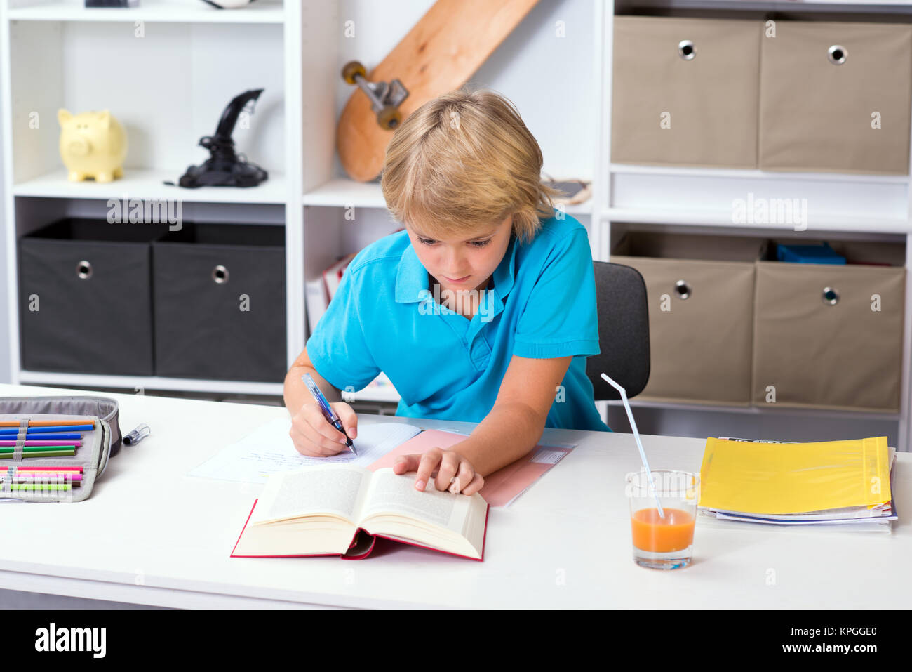 blond boy doing homework in his room Stock Photo - Alamy