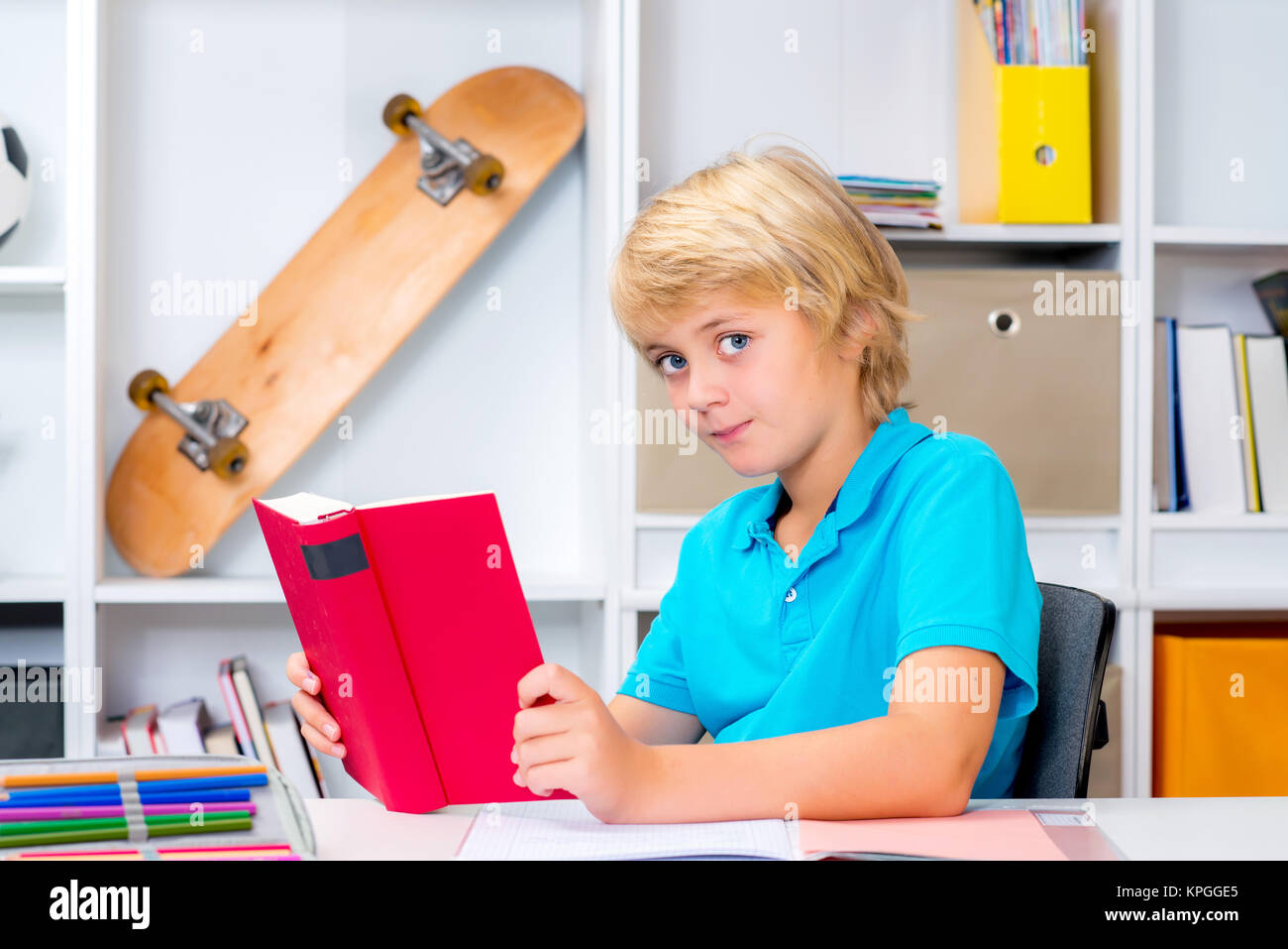 blond boy doing homework and reading a book Stock Photo - Alamy