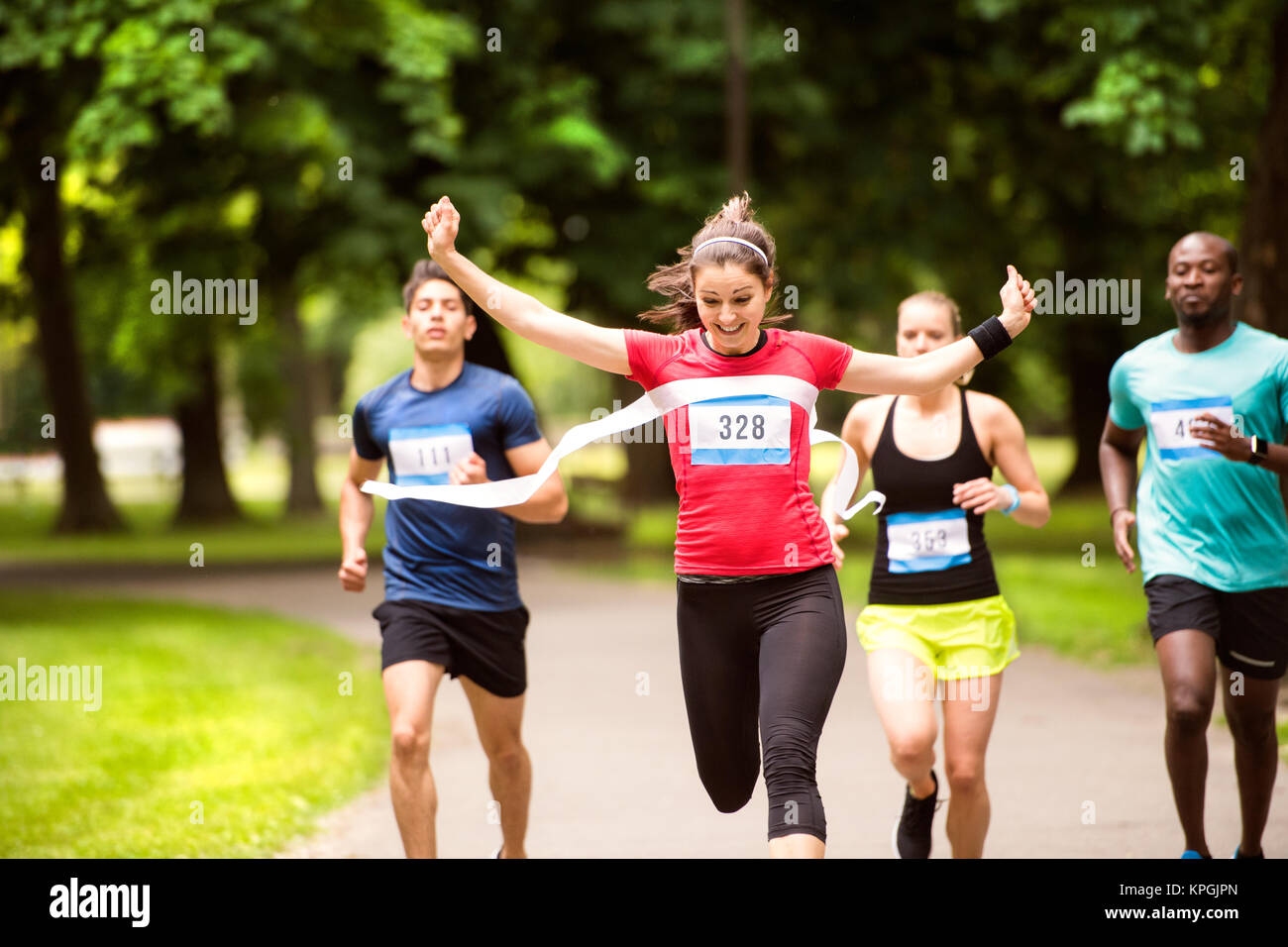 Young woman running in the crowd crossing the finish line Stock Photo ...