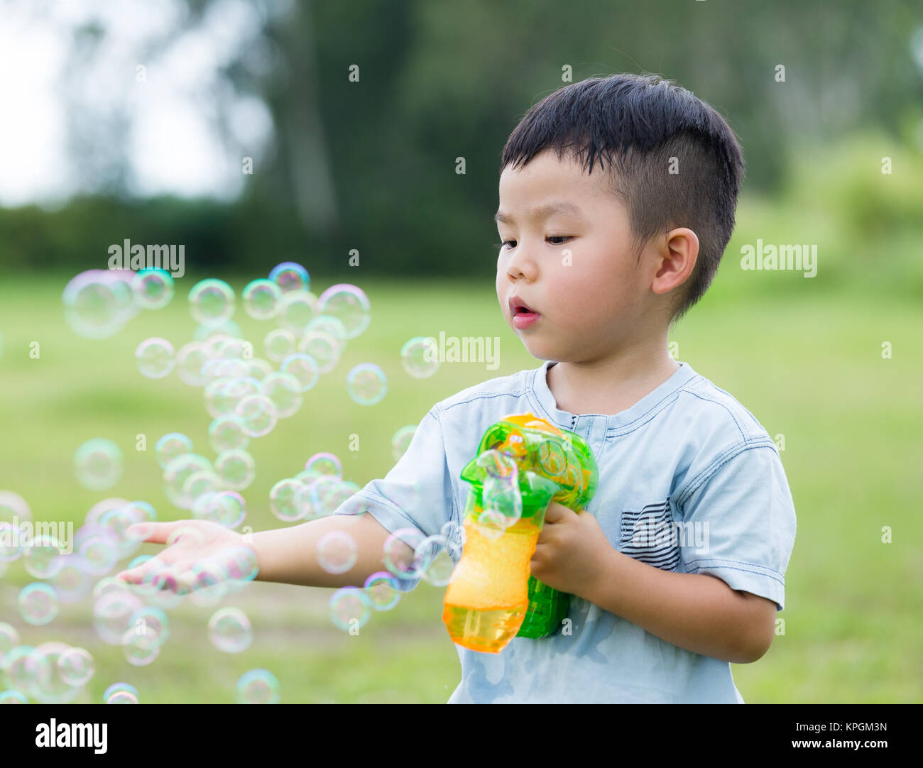 Young boy play with bubble gun and touch on the bubble Stock Photo - Alamy