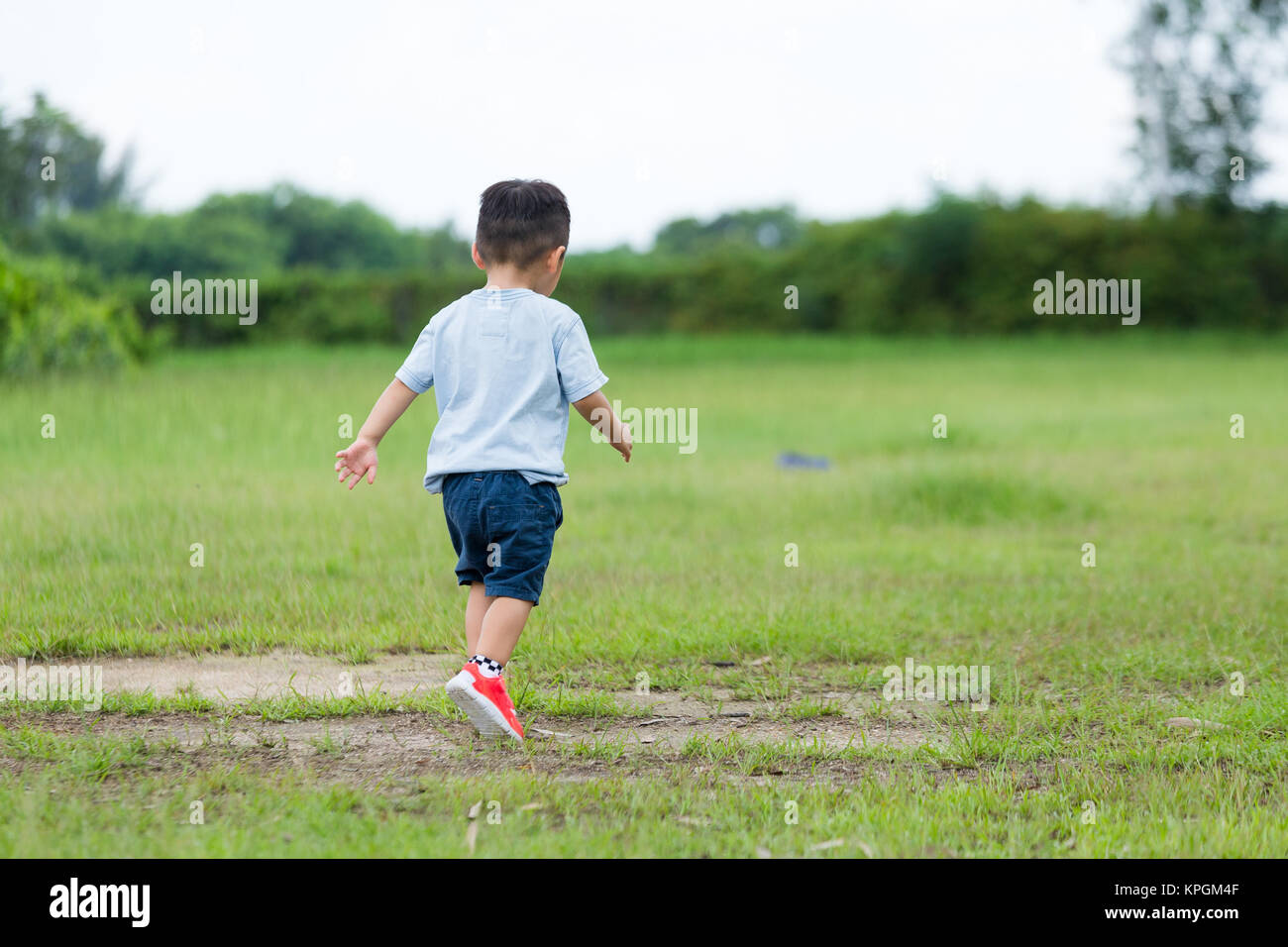 Back view of little boy running at park Stock Photo - Alamy