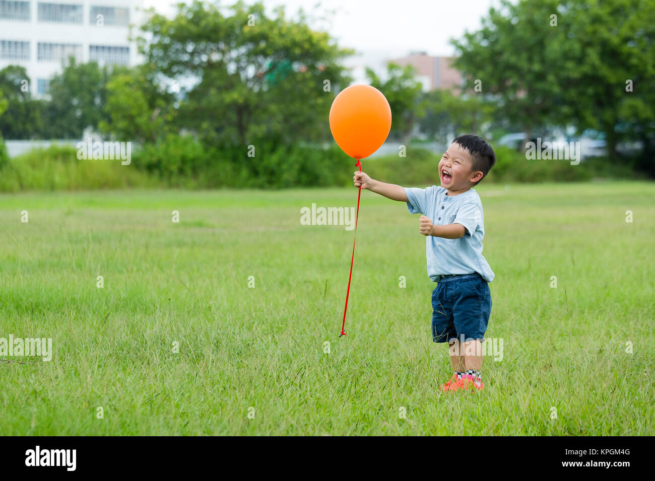 Little kid catch with flying balloon Stock Photo - Alamy