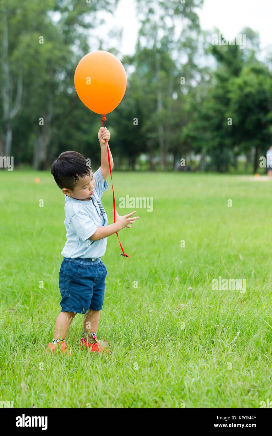 Young boy catching balloon Stock Photo - Alamy