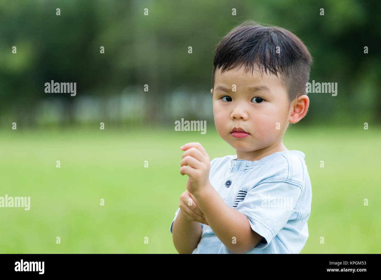 Asian kid scratching his arm Stock Photo - Alamy