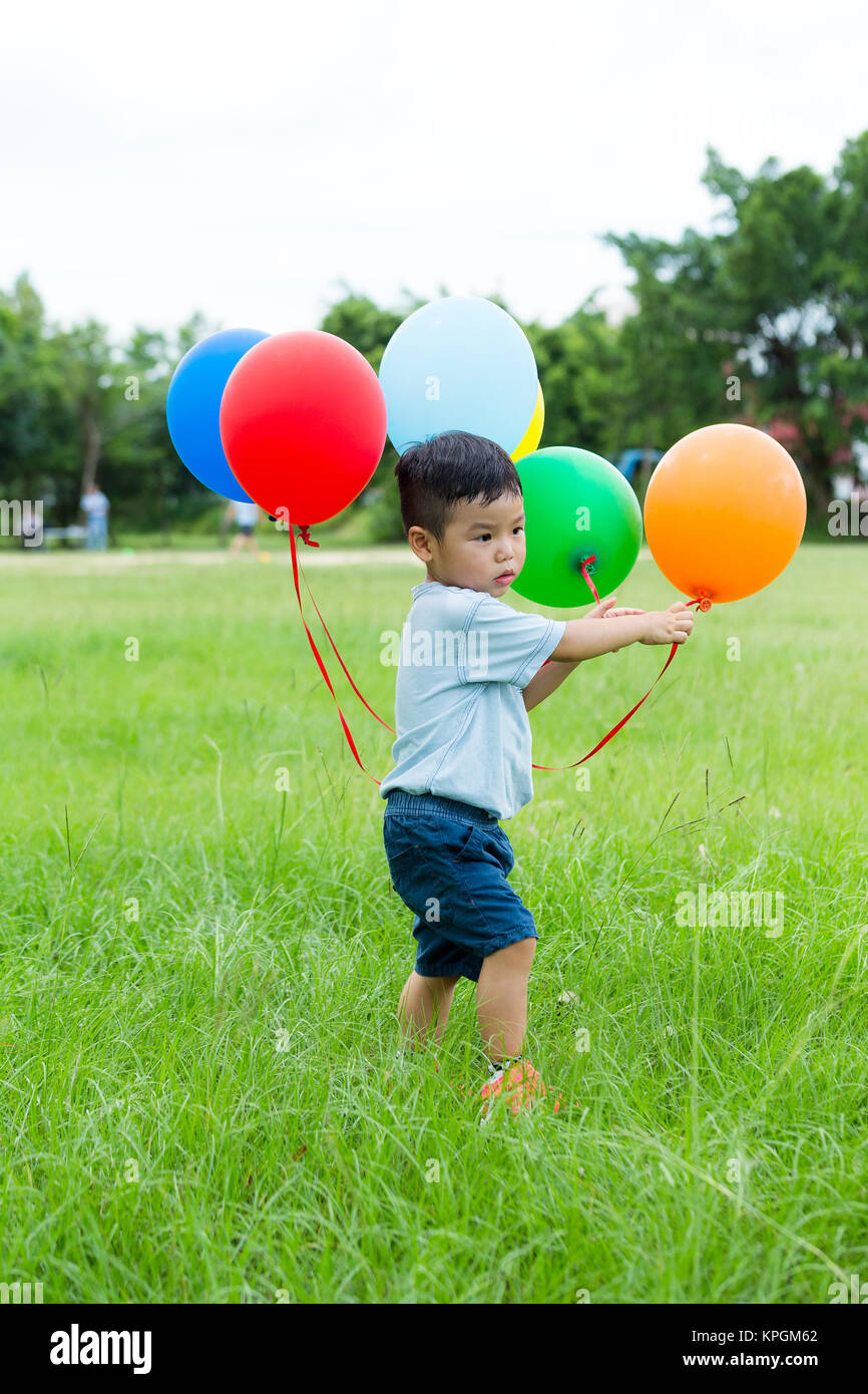 Asian baby boy play with his bunch of balloon Stock Photo - Alamy