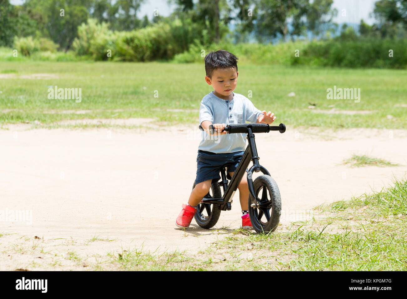 Small kid riding a bike Stock Photo - Alamy