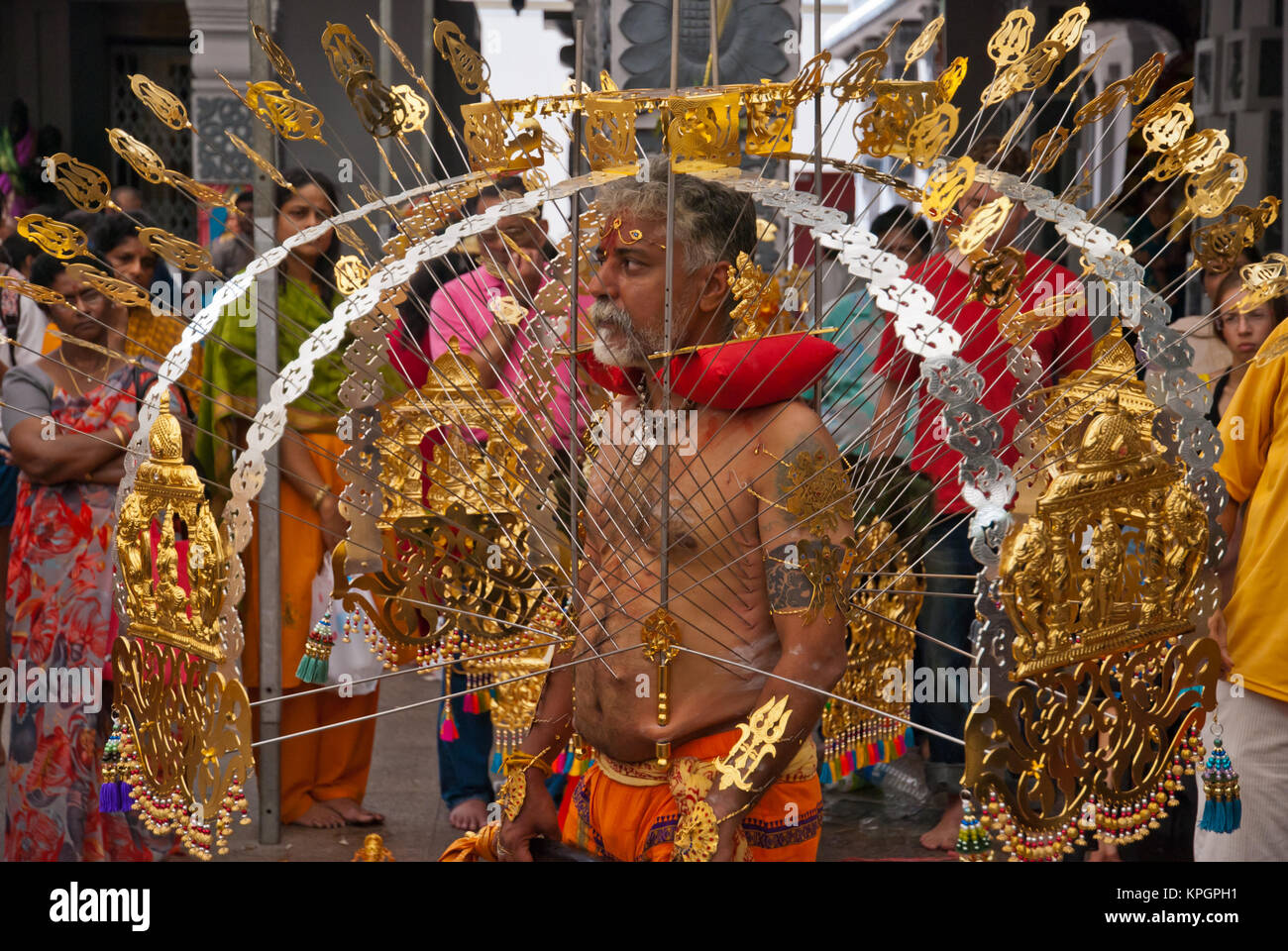 SINGAPORE - JANUARY 30: Elder Hindu devotee carrying a golden kavadi at ...