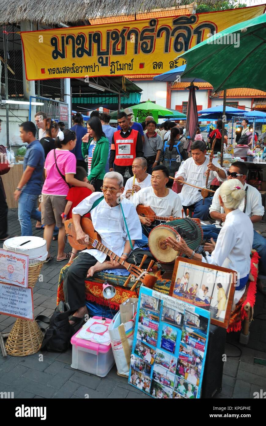 Adult street musicians performing on traditional instruments along a ...