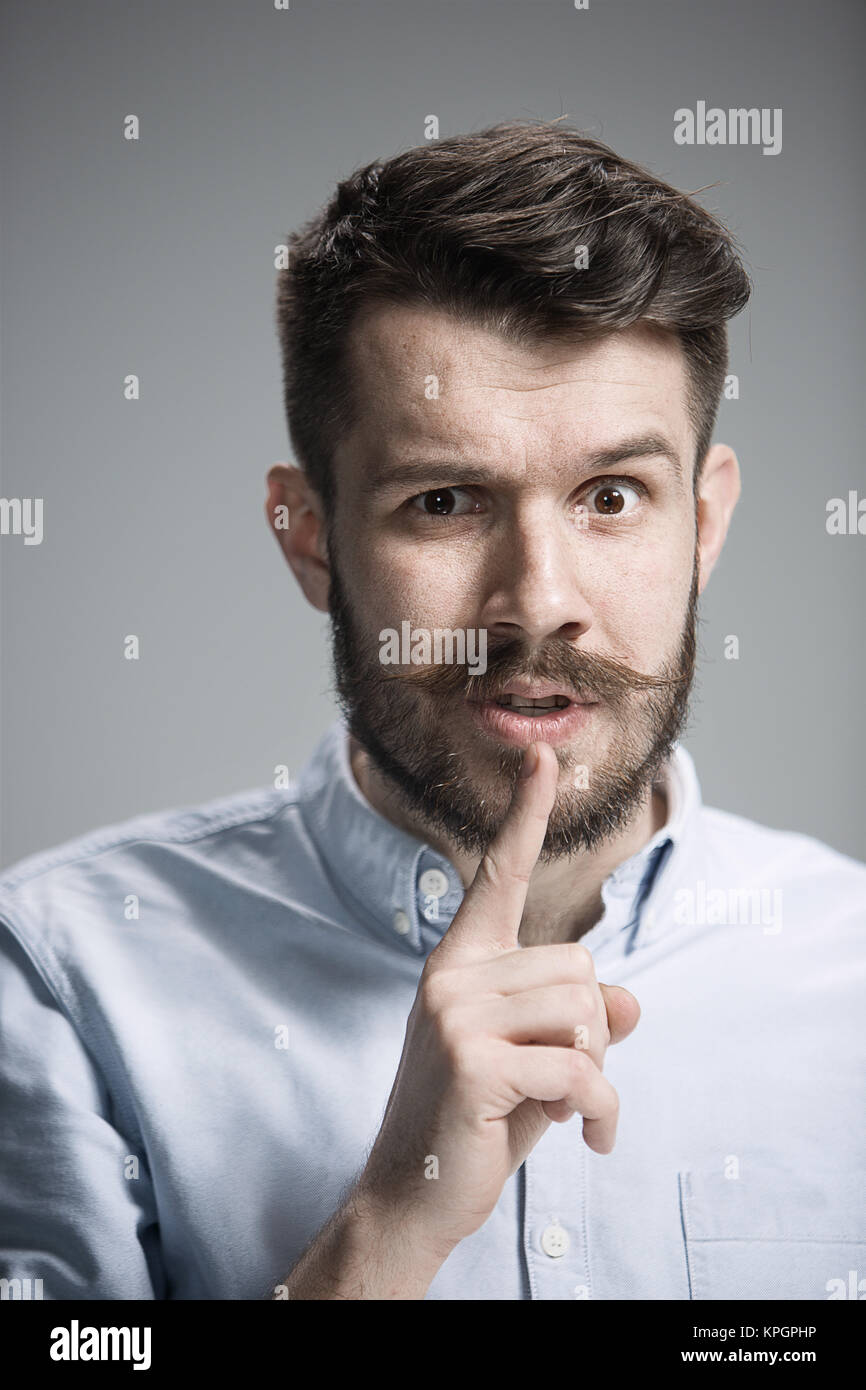 Man is looking wary. Over gray background Stock Photo - Alamy