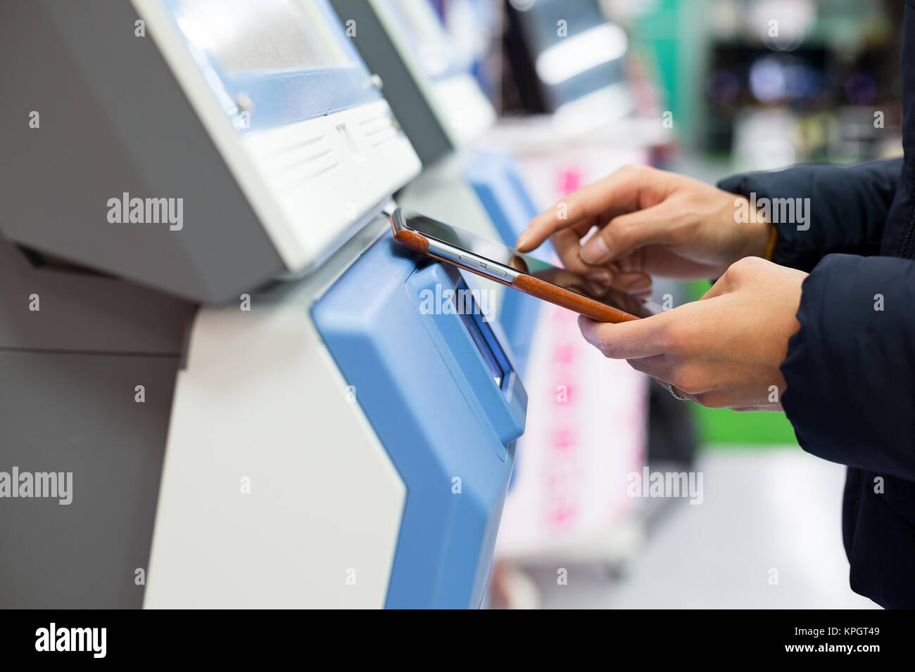Woman using cellphone for paying on machine Stock Photo - Alamy