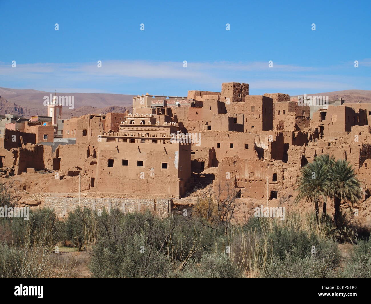 Old town of Tinghir, green palm oasis and rocky Atlas Mountains range ...