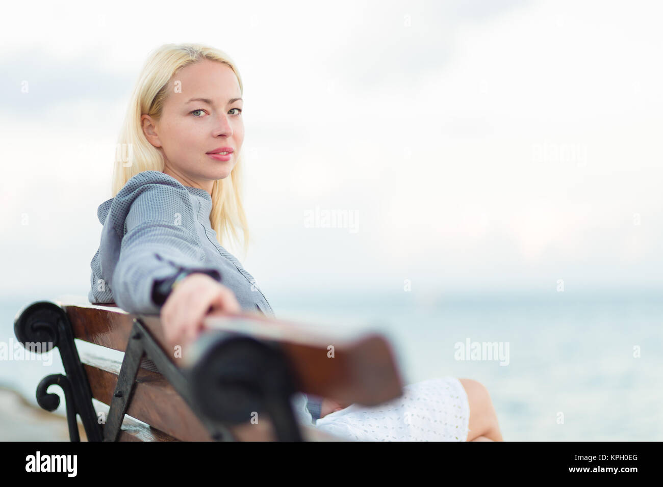 Lady sitting on a bench outdoors Stock Photo - Alamy
