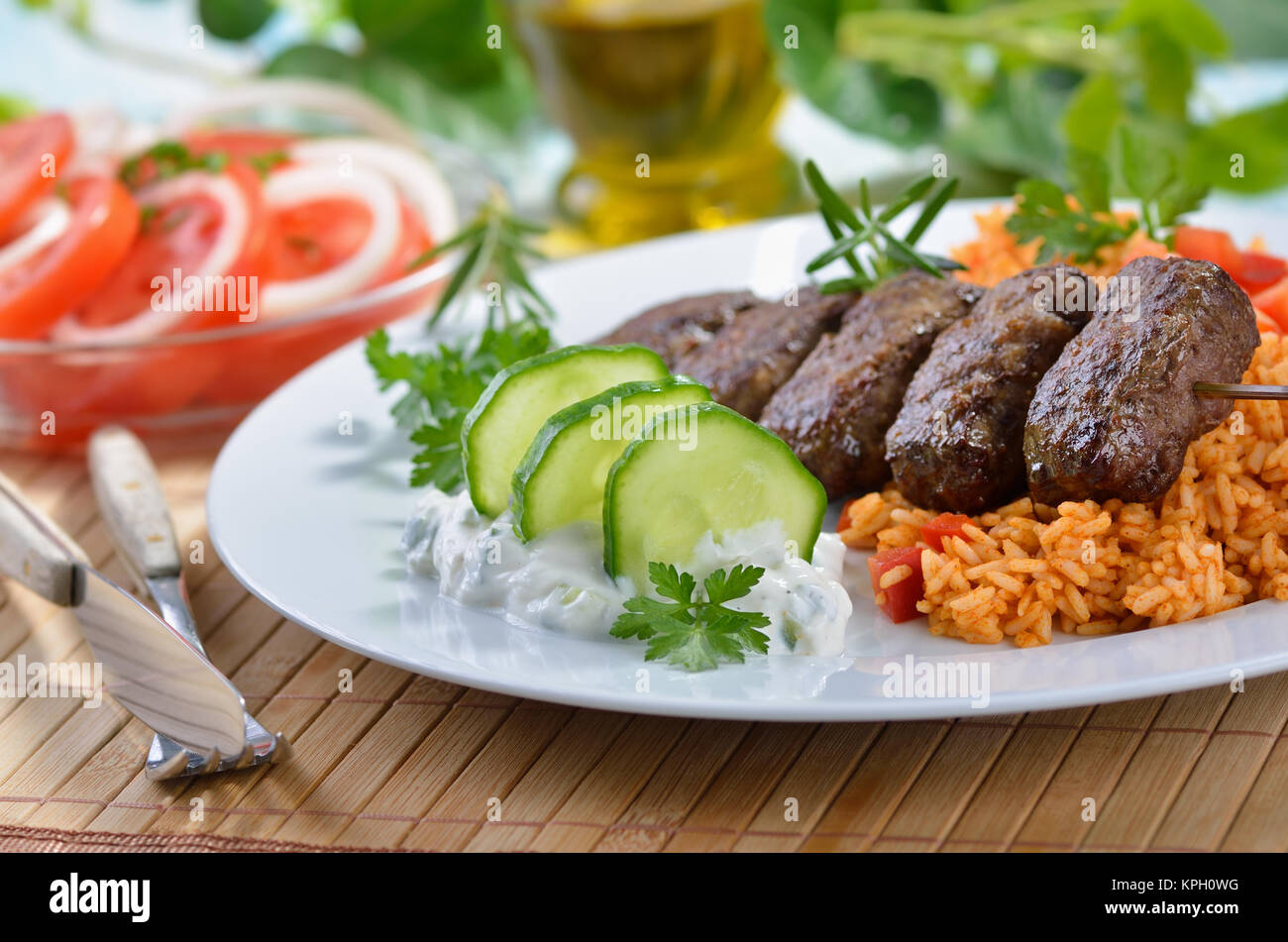 Greek meat balls with paprika rice and tsatsiki, in the background ...