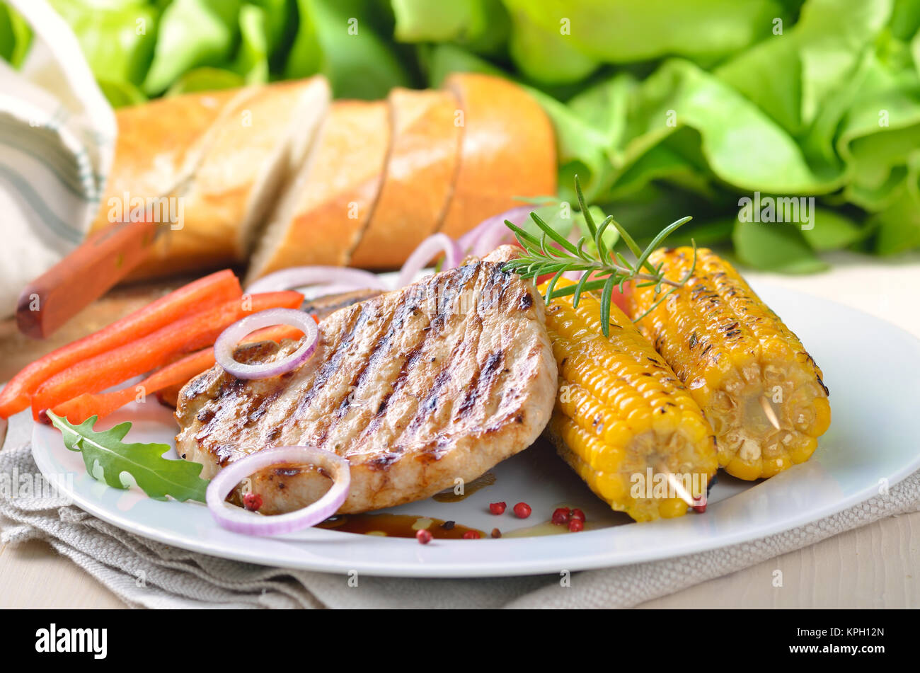 Hot, tasty, delicious grilled pork steak meal with corn on the cob ...