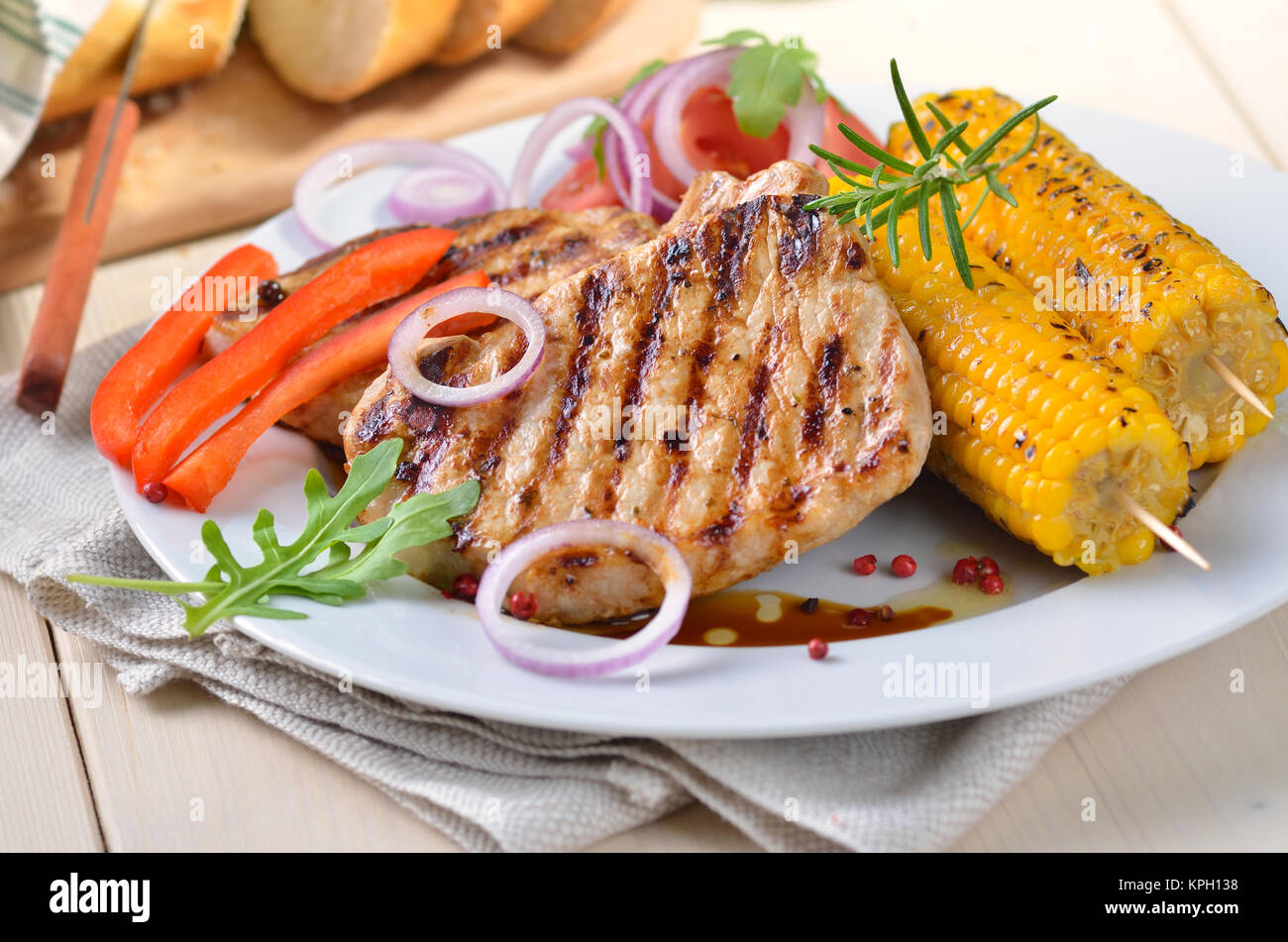 Hot, tasty, delicious grilled pork steak meal with corn on the cob ...