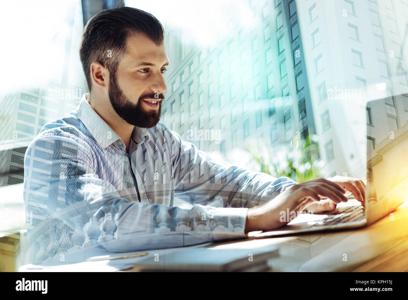 Handsome good-looking man sitting and using laptop Stock Photo - Alamy