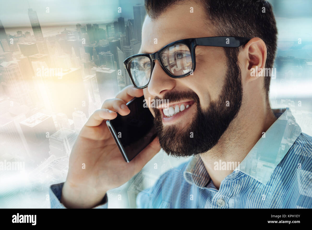 Funny bespectacled man having phone conversation and smiling Stock ...