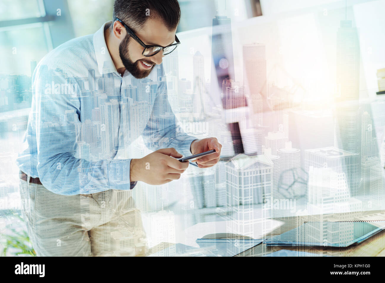 Joyful nifty man keeping the smartphone and making photo Stock Photo ...
