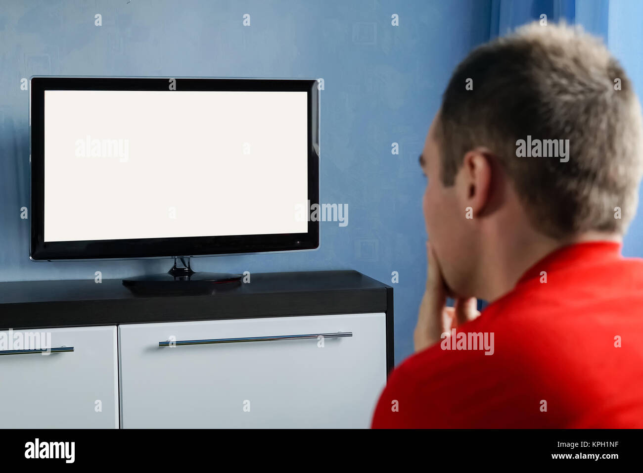 The young man stares at the TV. Blank screen white screen. The form for ...