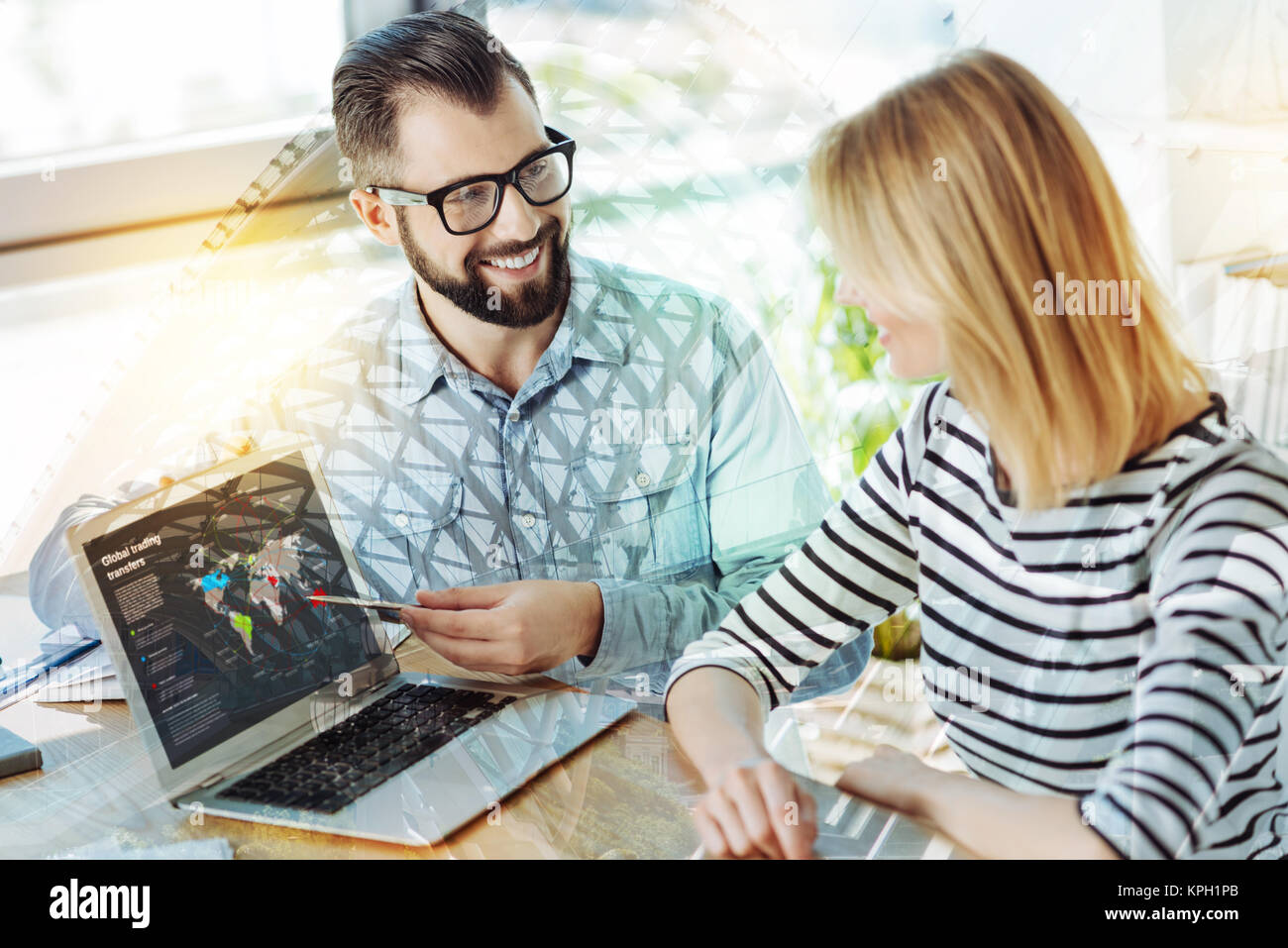 Pleasant kind man sitting and showing the computer program Stock Photo ...