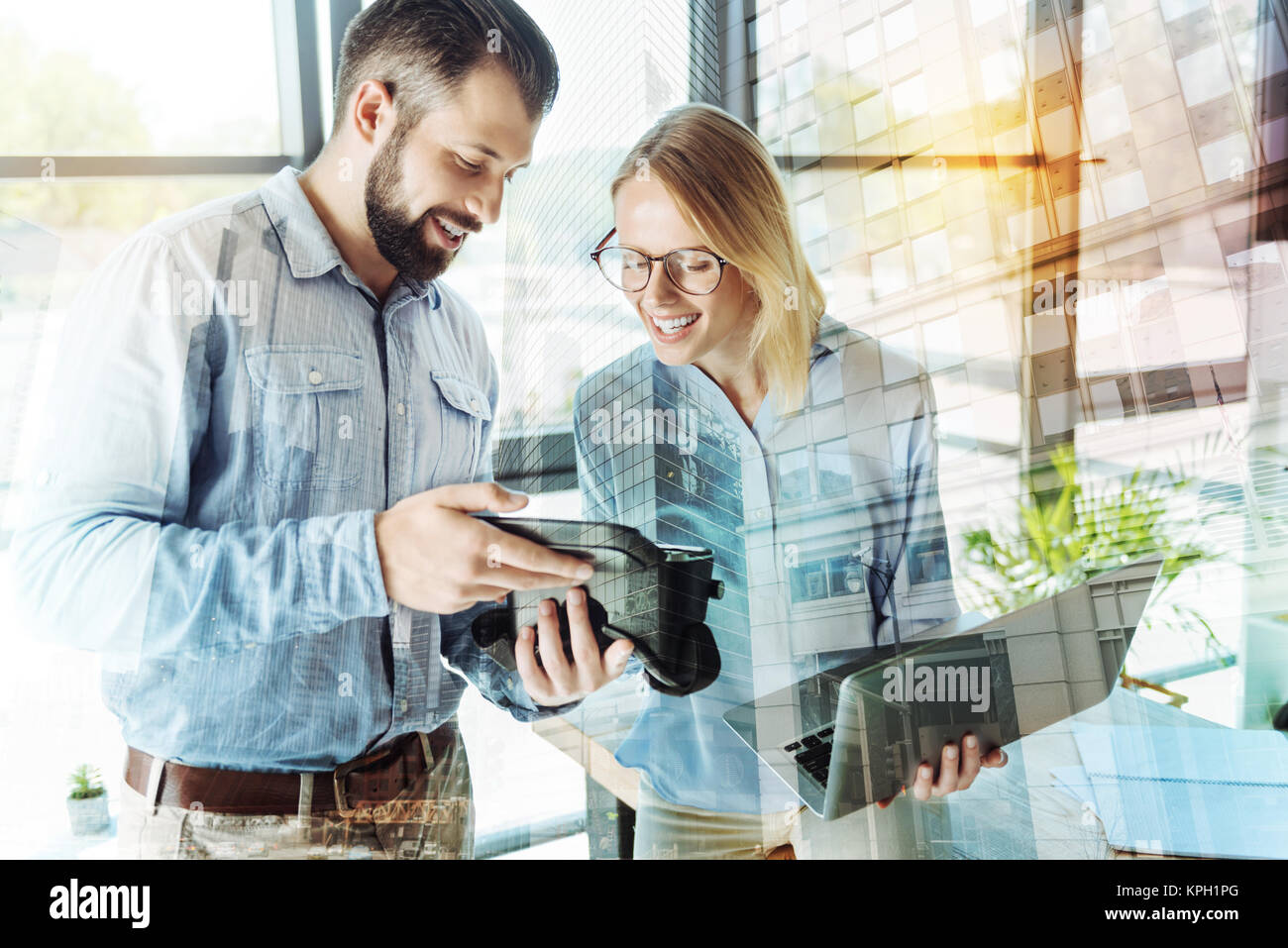 Joyful surprised employees keeping gadgets and observe it Stock Photo ...