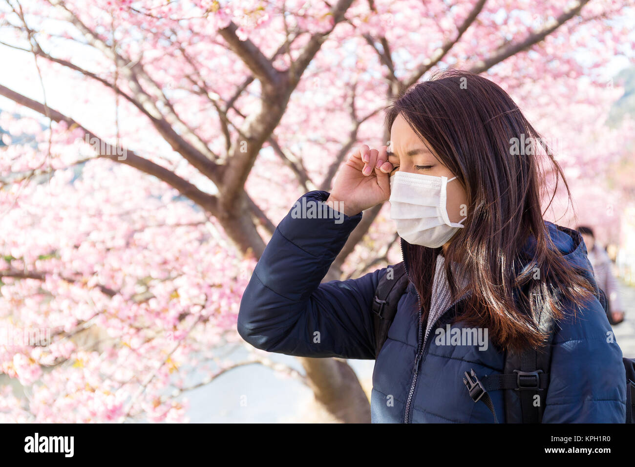 Woman suffer from Pollen allergy under sakura tree Stock Photo - Alamy