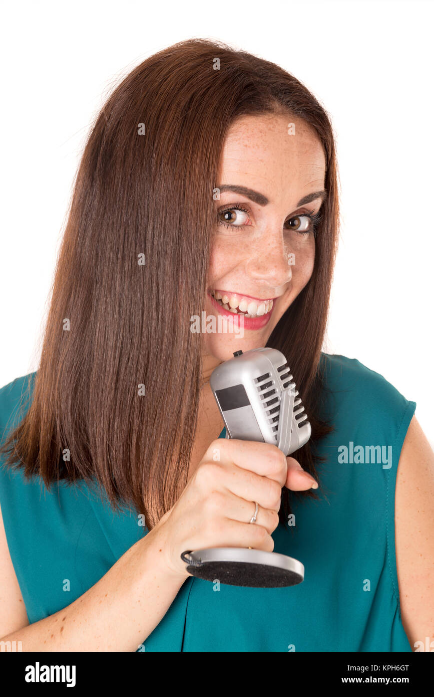 Casual young woman with a microphone isolated in a white background ...