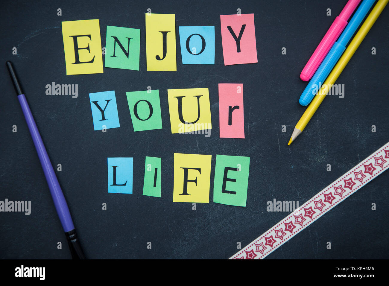 Enjoy your life inscription on a blackboard. Letters printed on colored ...