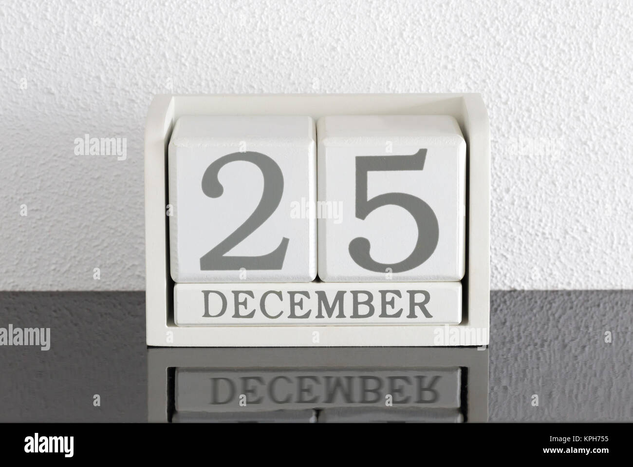 White block calendar present date 25 and month December on white wall ...